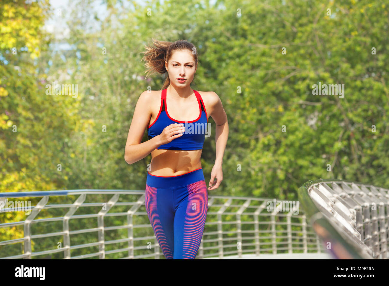 Beautiful woman running across the city park Stock Photo - Alamy