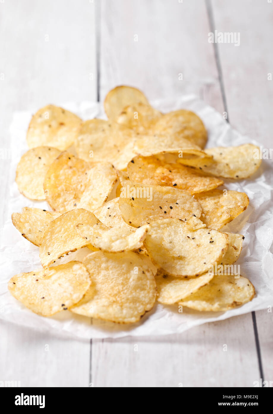 Crispy delicious pepper potato crisps chips snack on white wooden and ...