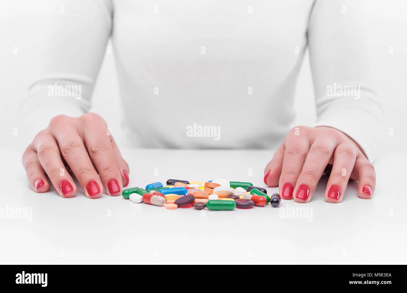 Woman chooses medicine from a handful of different color tablets Stock ...