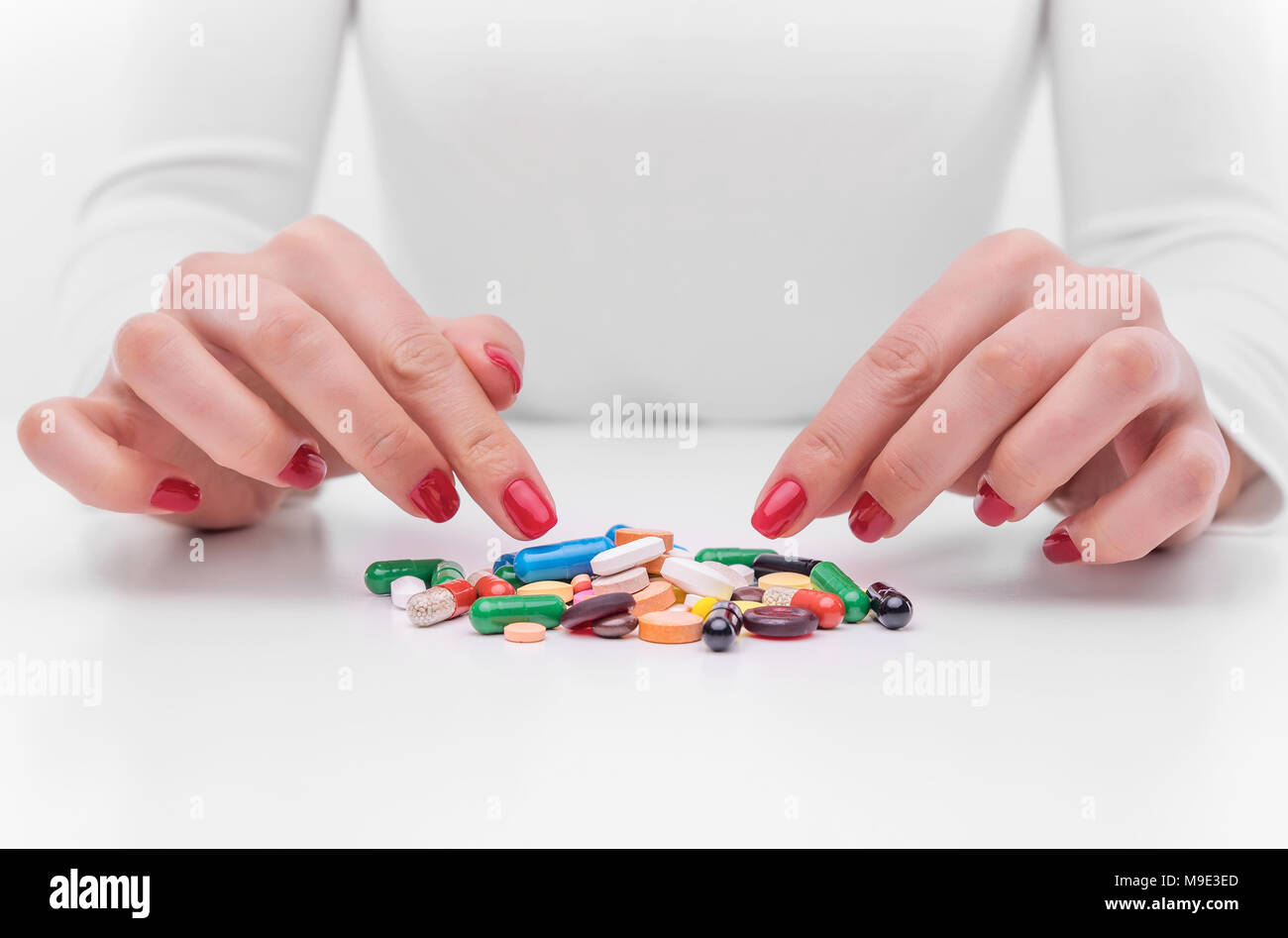 Woman chooses medicine from a handful of different color tablets Stock ...