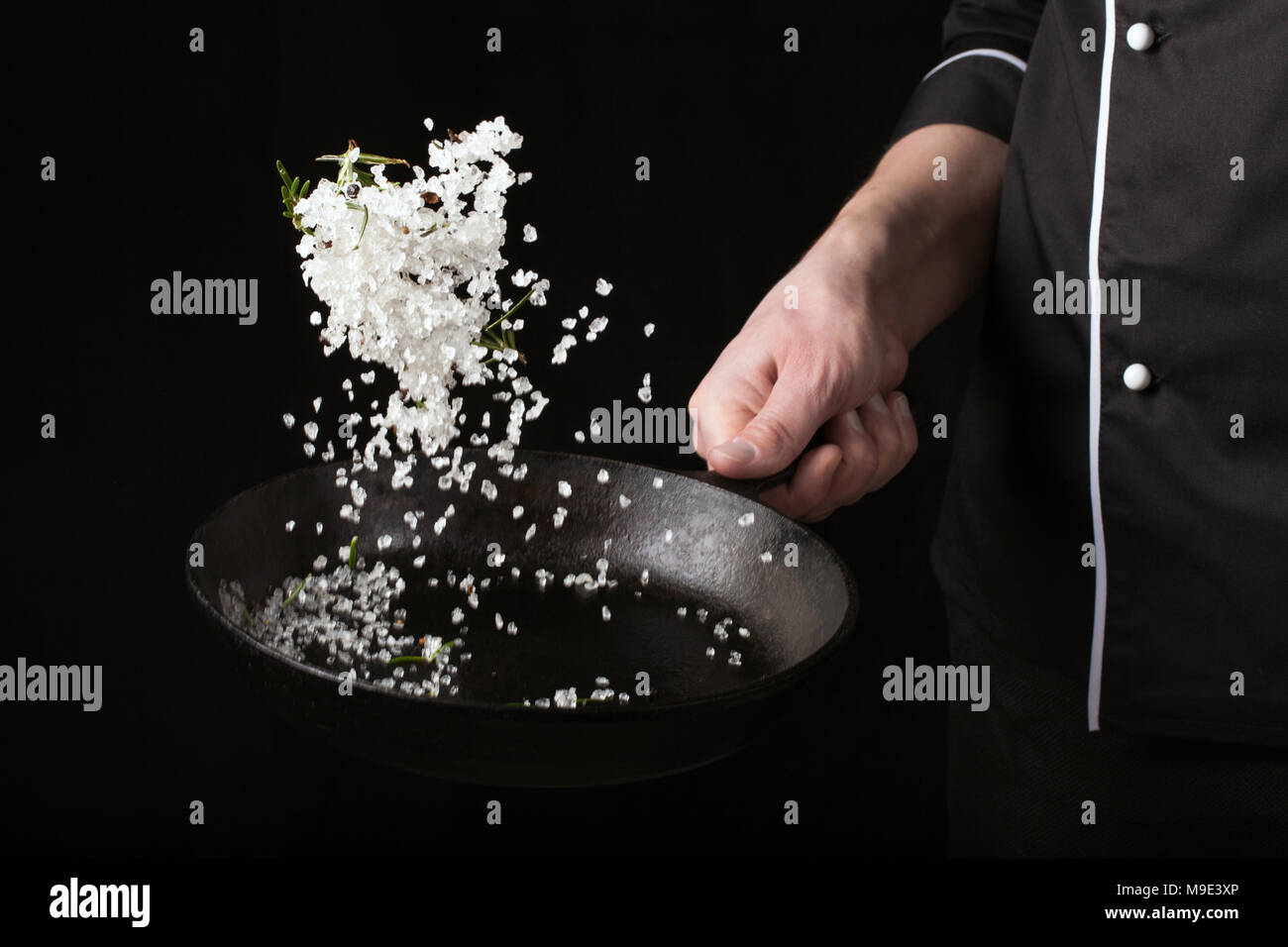 Cooking roasted aromatic salt in a pan by chef hand. Horizontal photo ...