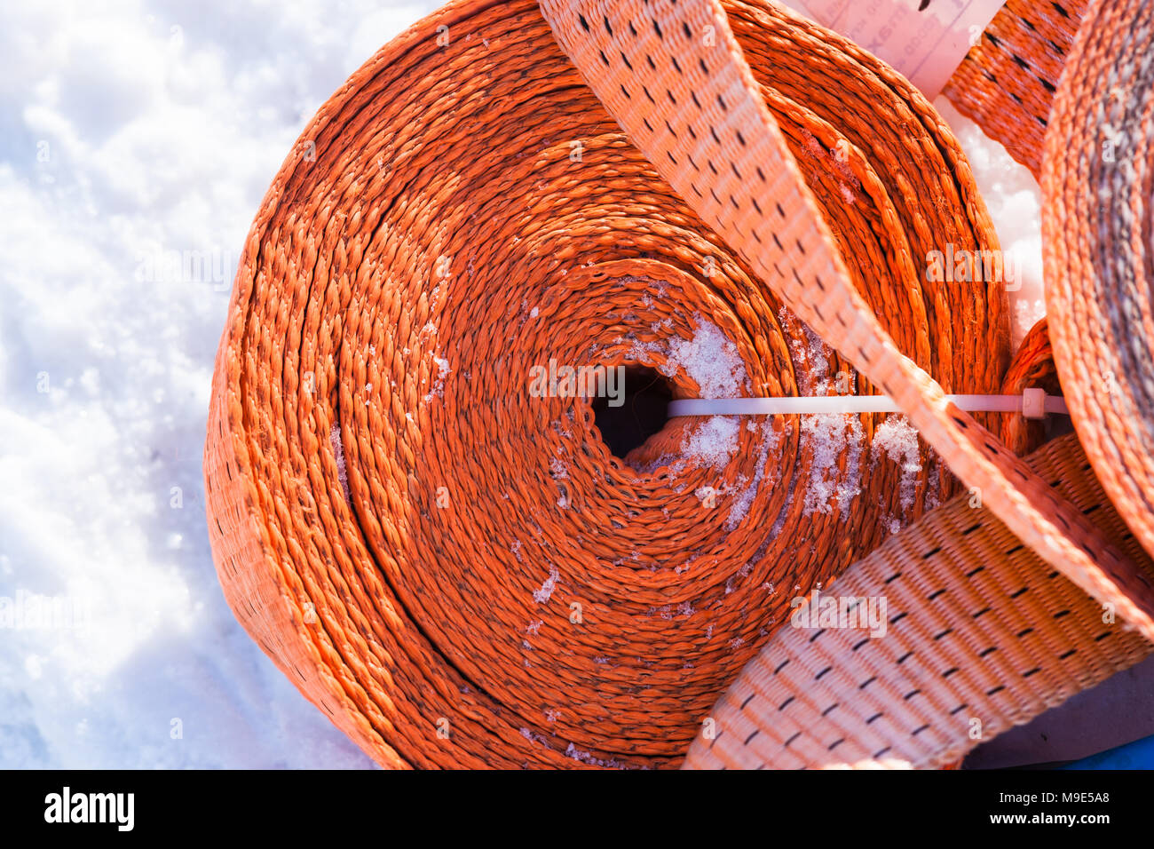 Bunch of orange plastic construction tape in snow. Decorative pattern ...