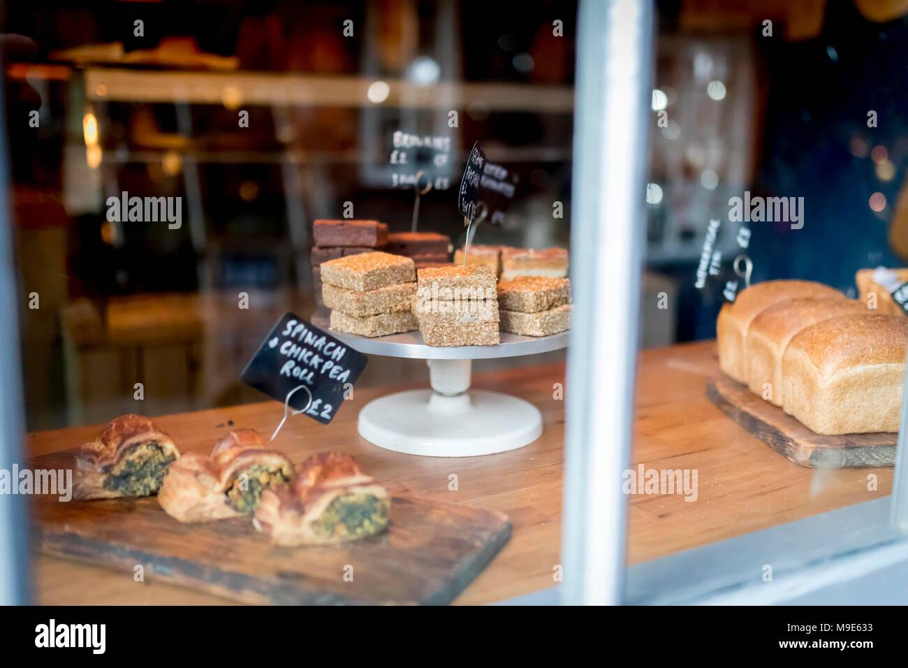 Flapjack and cake selection on a display on a cake stand in a bakery ...