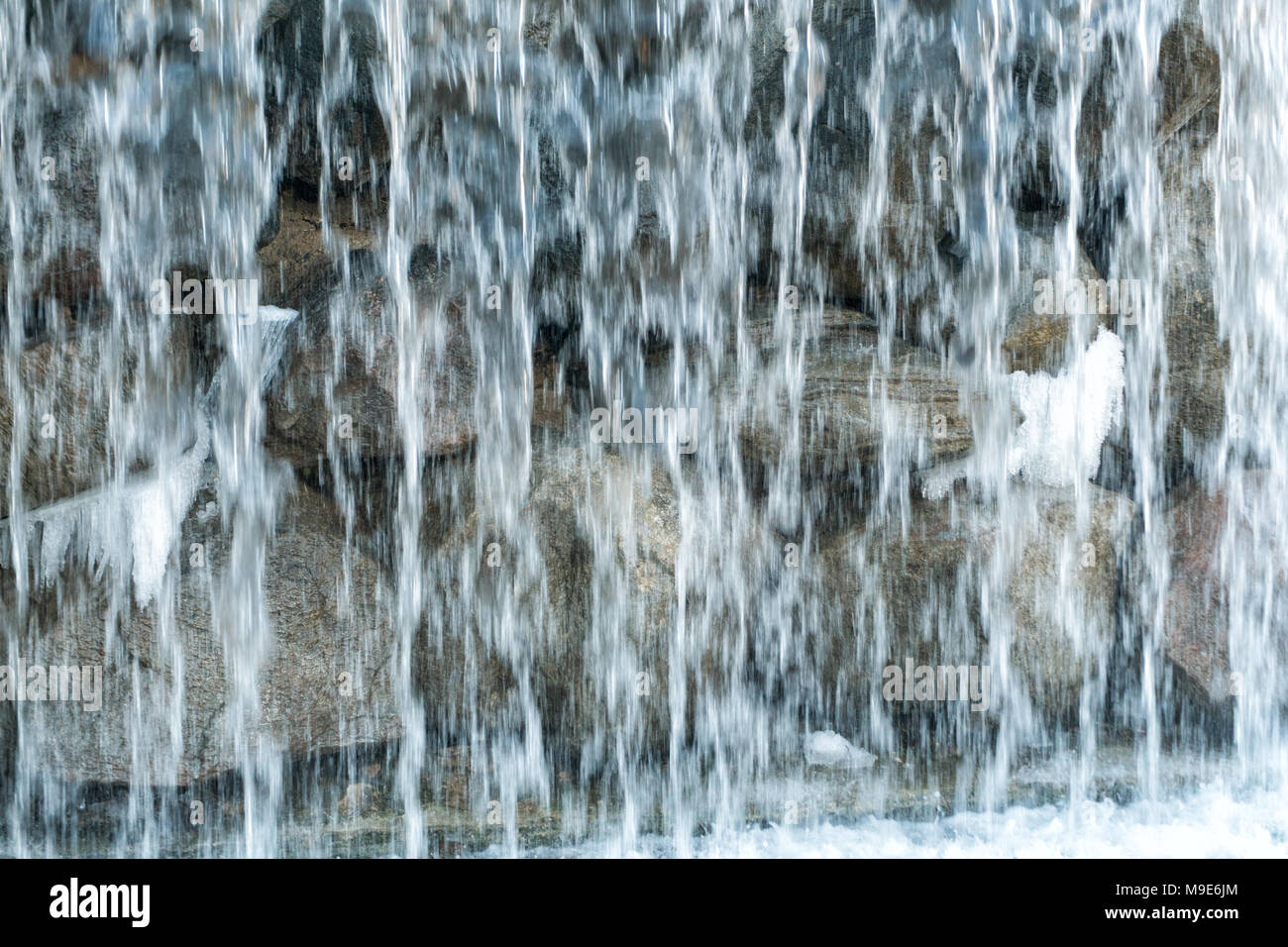 Artificial waterfall spring water flows into the lake Stock Photo - Alamy
