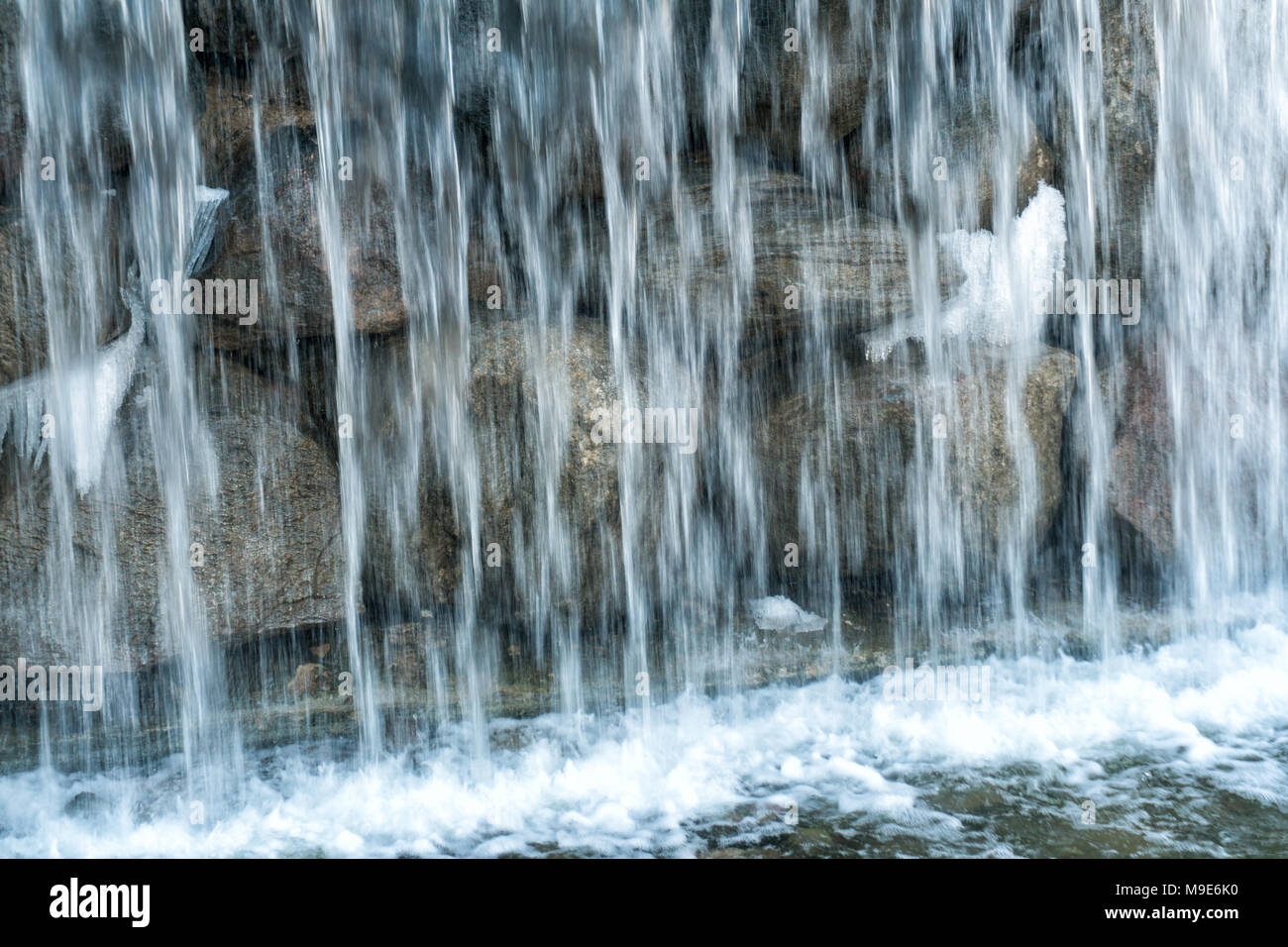 Artificial waterfall spring water flows into the lake Stock Photo - Alamy