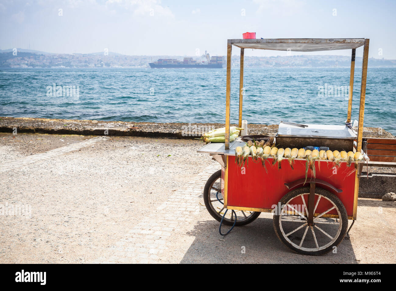 Red selling cart with boiled and roasted corn stands on coast of ...