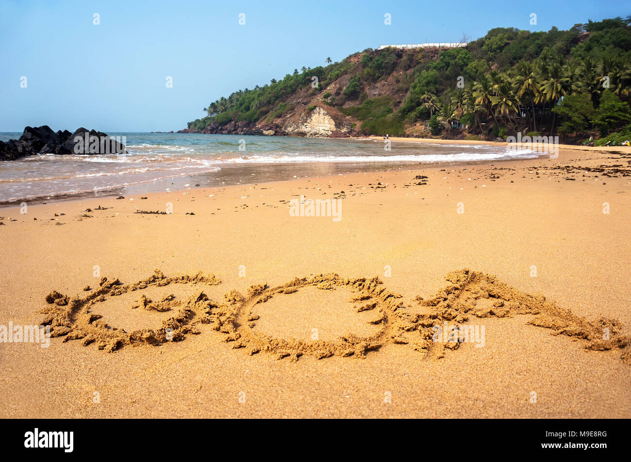 Text GOA on the sand on the beach on the background of blue sea and ...