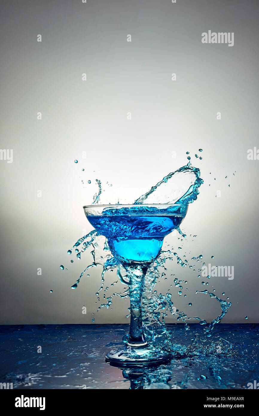 Glass with blue champagne or alcohol drink cocktail, martini glasses ...