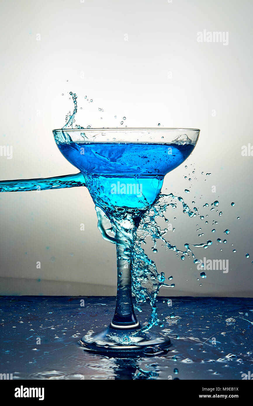 Glass with blue champagne or alcohol drink cocktail, martini glasses ...