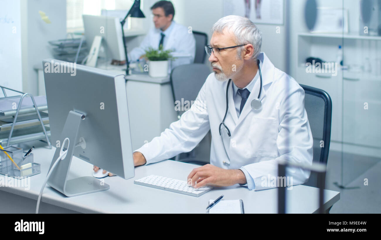 Senior doctor assistant working desktop hi-res stock photography and ...