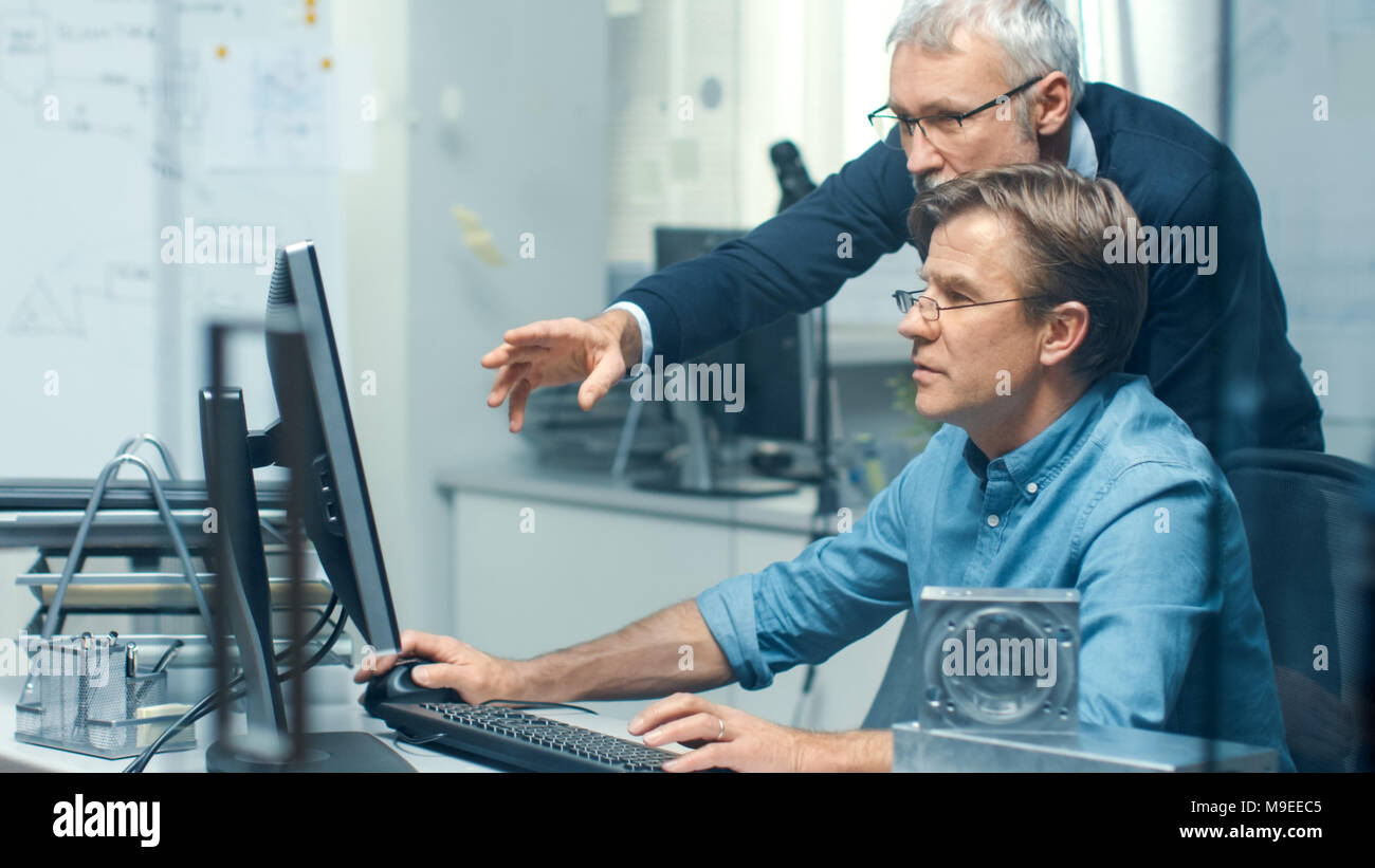 In Busy Engineering Bureau Two Senior Engineers Discussing Technical ...