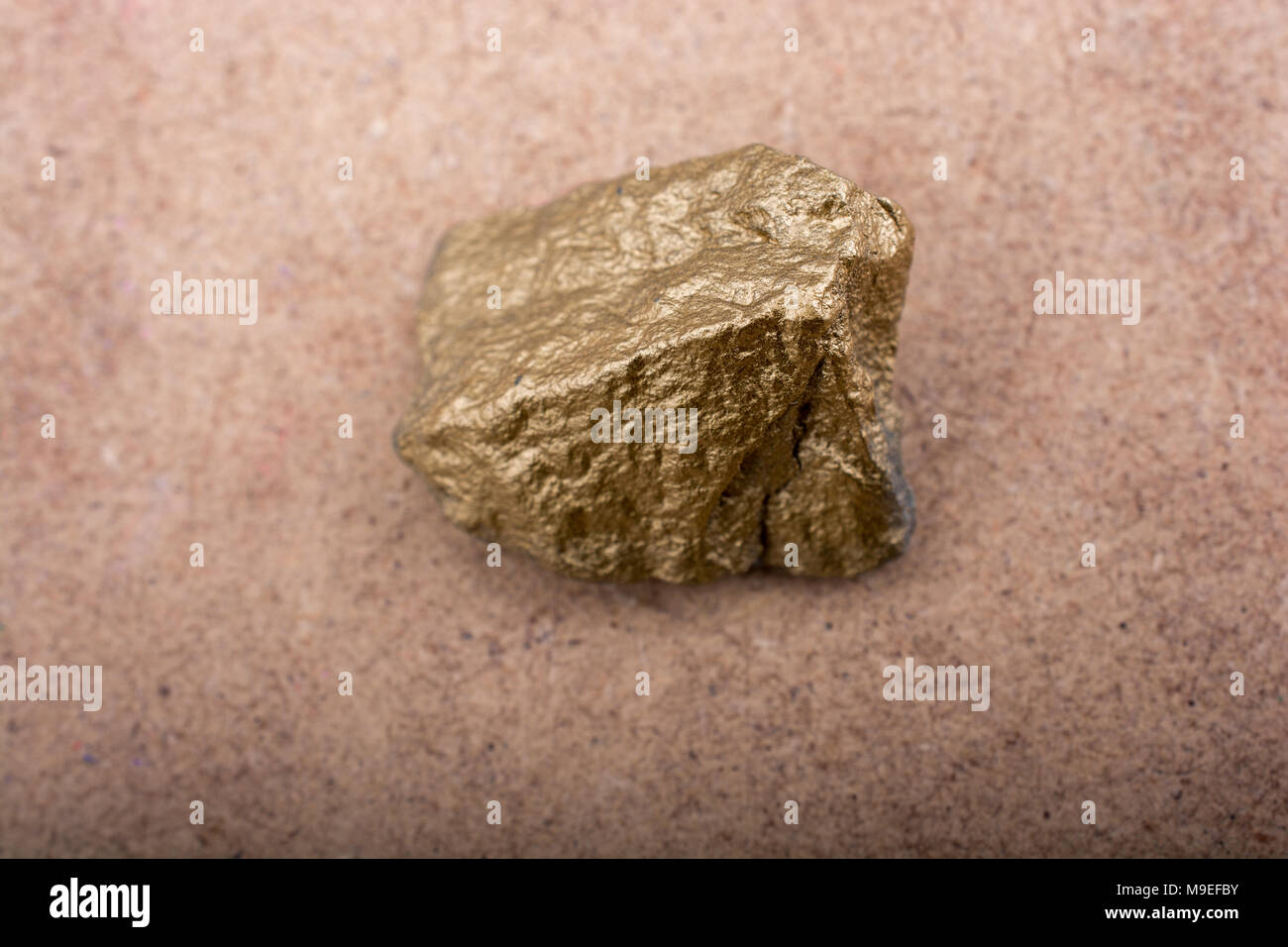 little gold color stone on brown background Stock Photo - Alamy