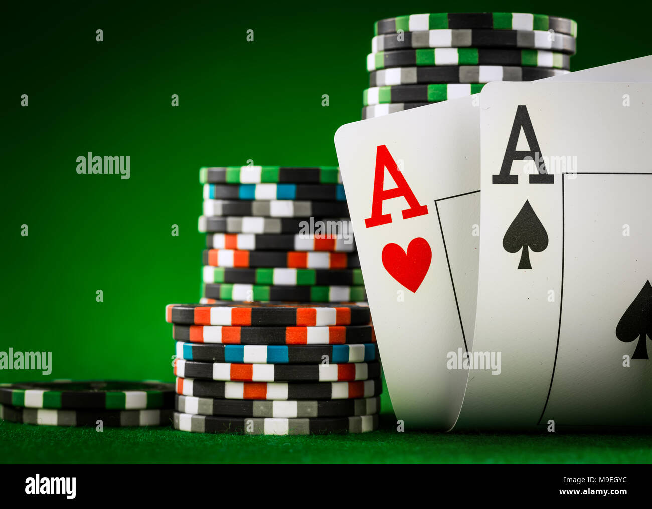 Stack of chips and two aces on the table on the green baize - poker ...