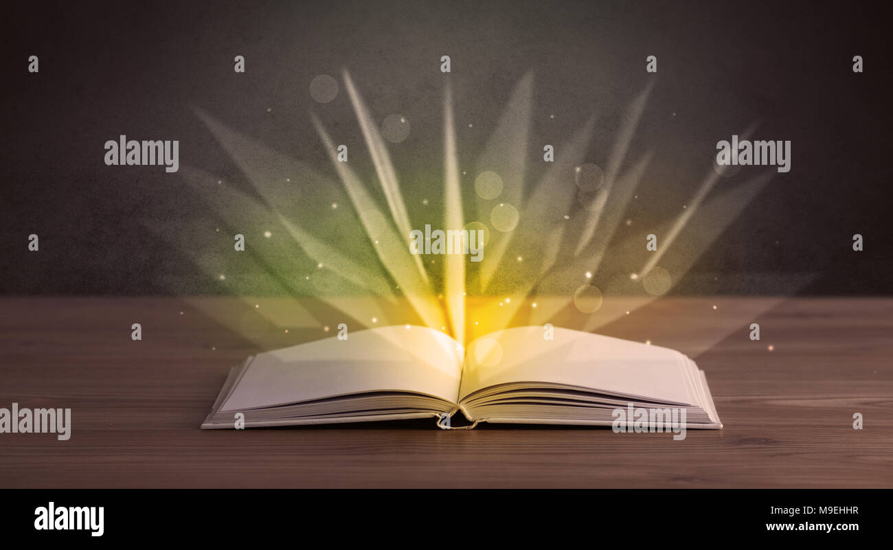 Yellow lights spreading from an open book Stock Photo - Alamy
