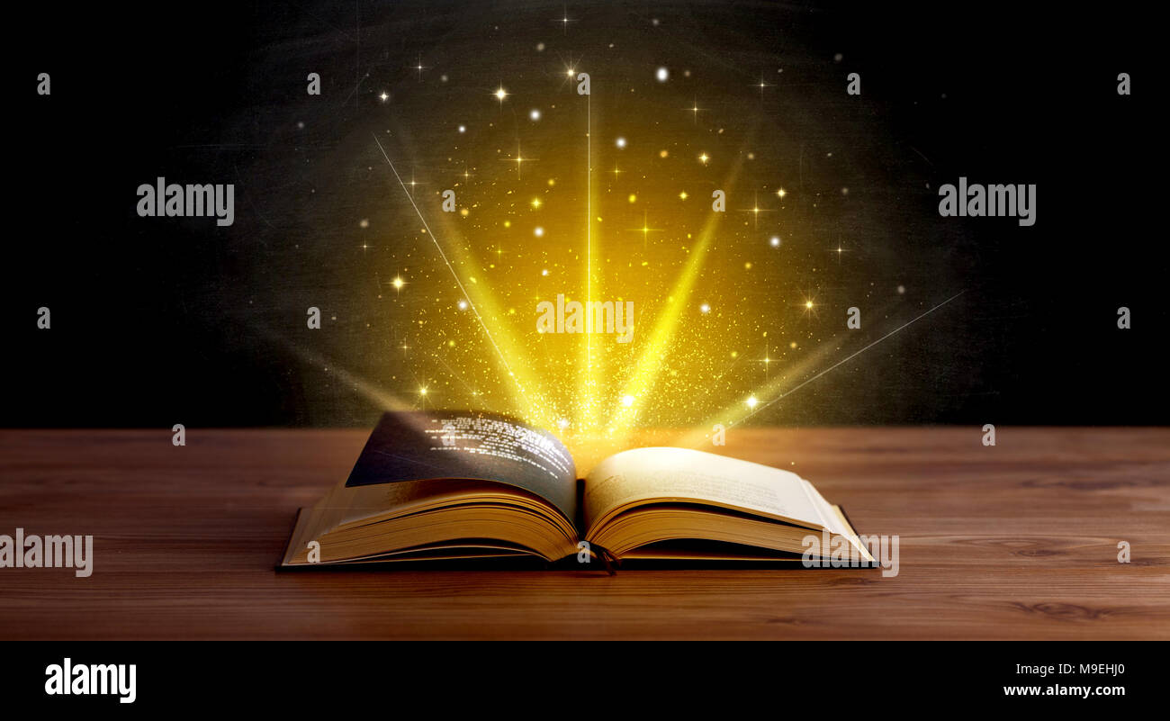 Yellow lights and sparkles coming from an open book Stock Photo - Alamy