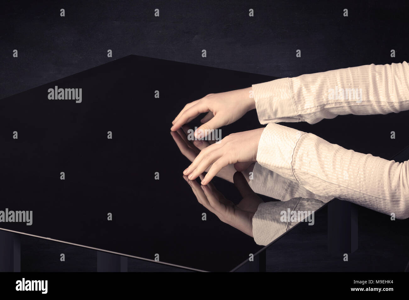 Close up of a hand touching smart table with copy space on black ...