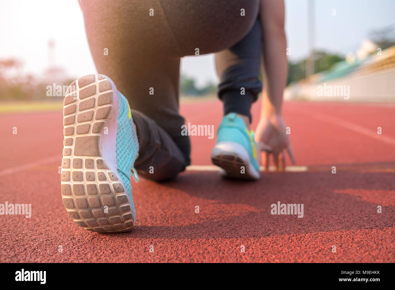 Rear view of young woman get ready to run on track, training and ...