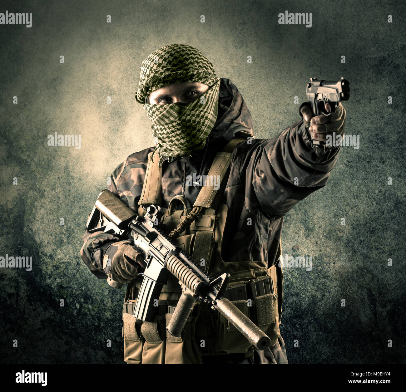 Portrait of a heavily armed masked soldier with grungy background ...