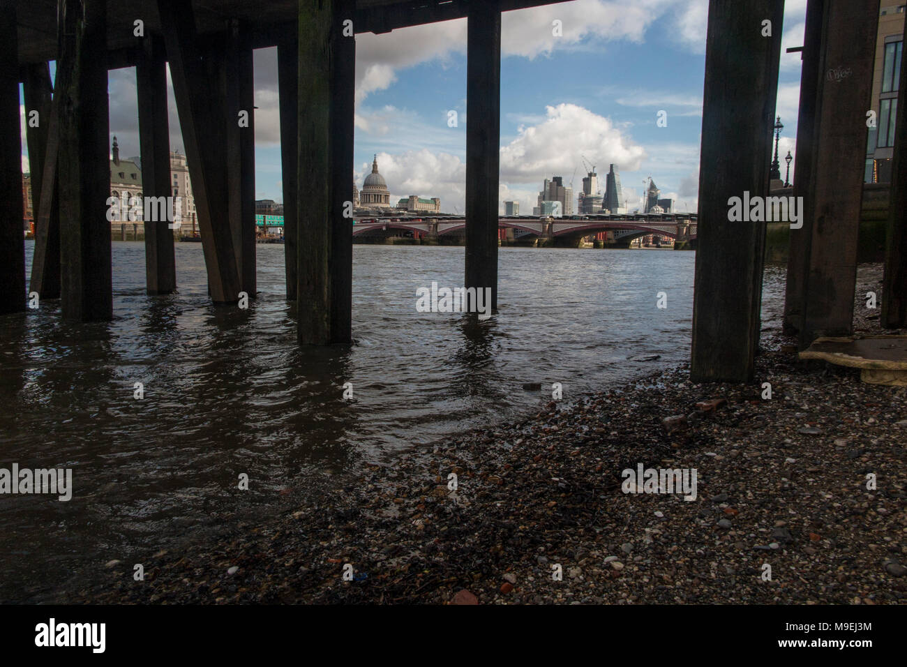 an unusual view o the City of London from underneath the wooden jetty ...