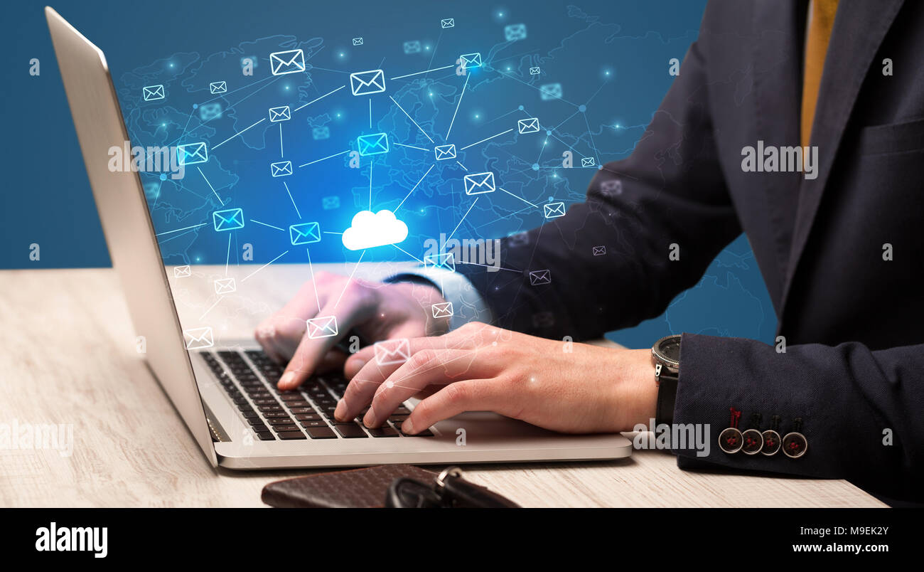 Businessman hand sending a bunch of messages on laptop with cloud ...