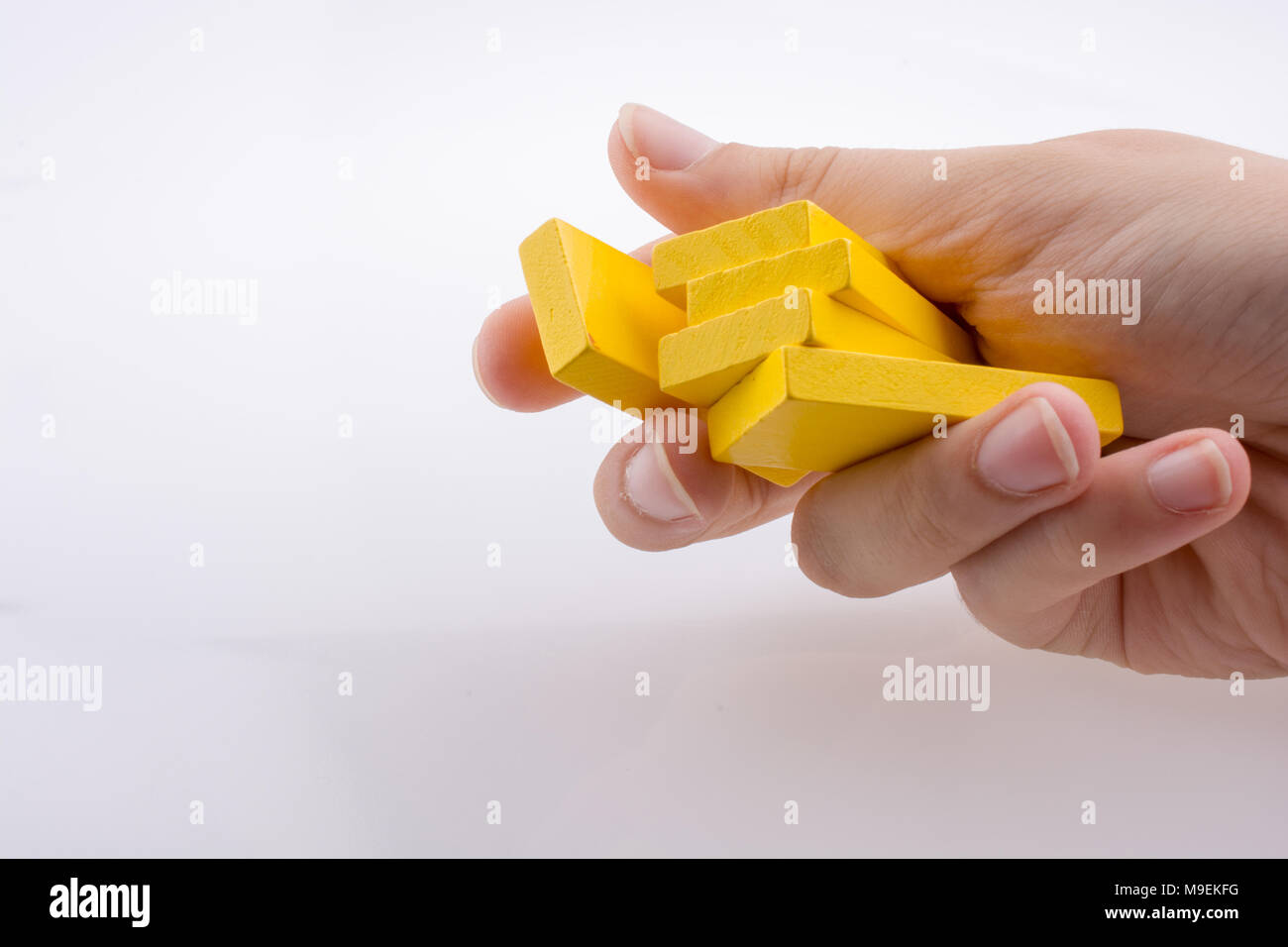 Hand holding yellow color domino pieces in hand Stock Photo - Alamy