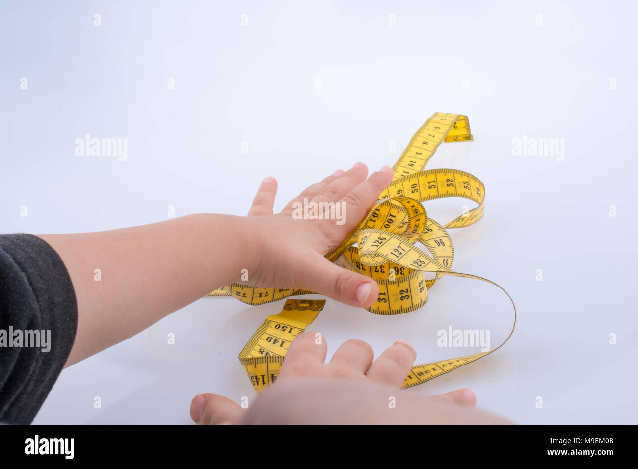Hand holding a yellow color measuring tape on a white background Stock ...