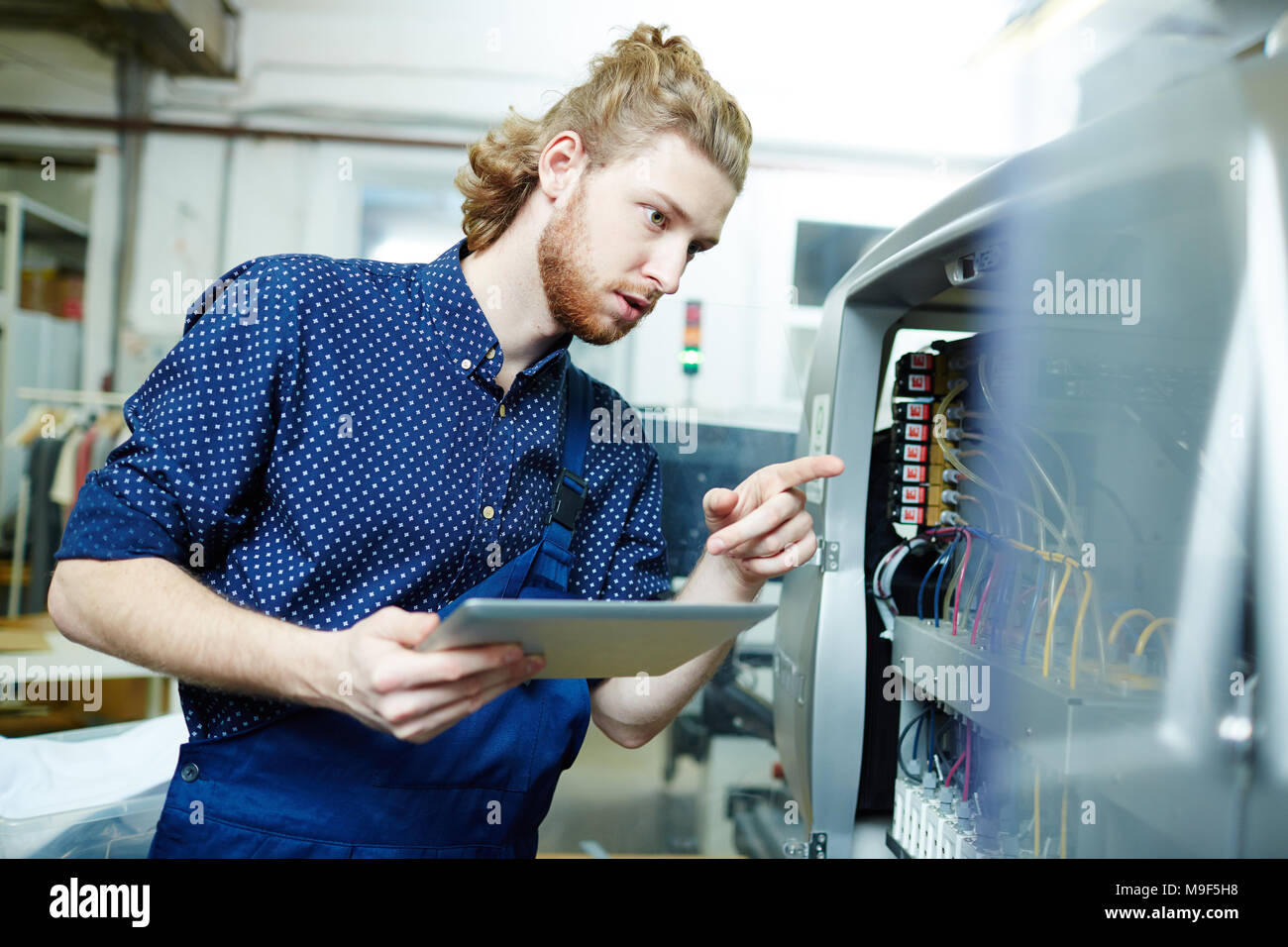 Young operator examining printing machine on factory Stock Photo - Alamy