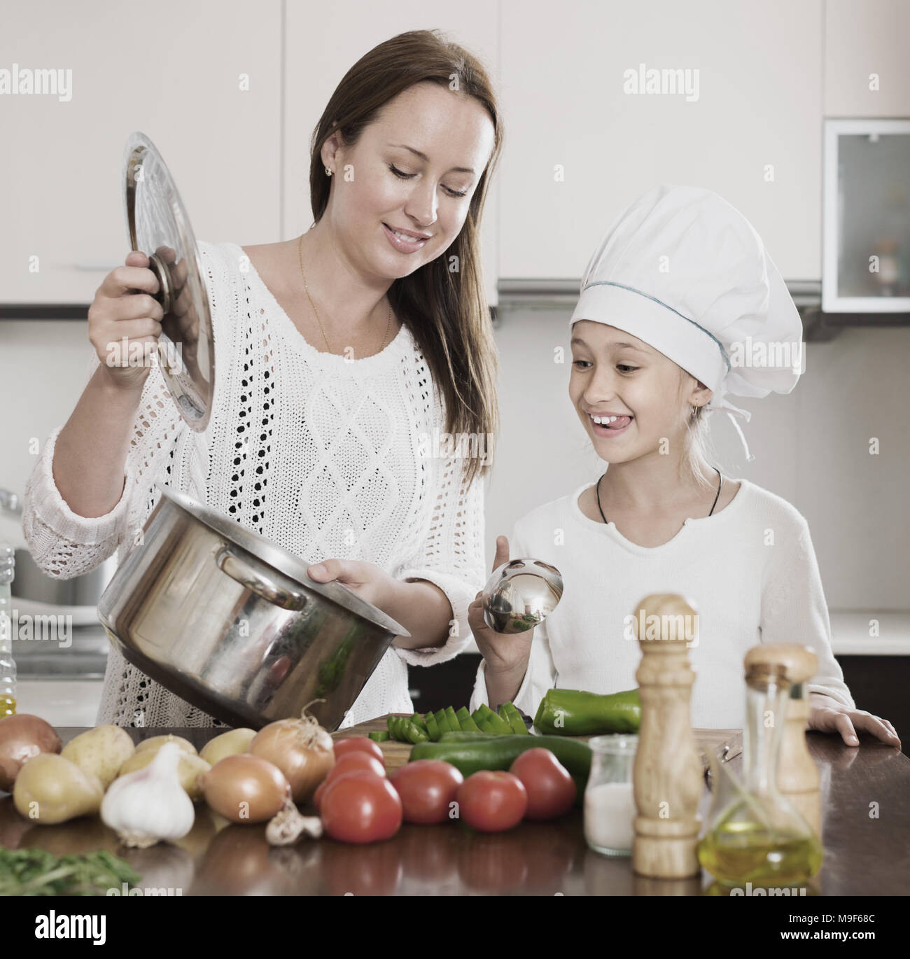 Happy mother and little daughter preparing soup together Stock Photo ...