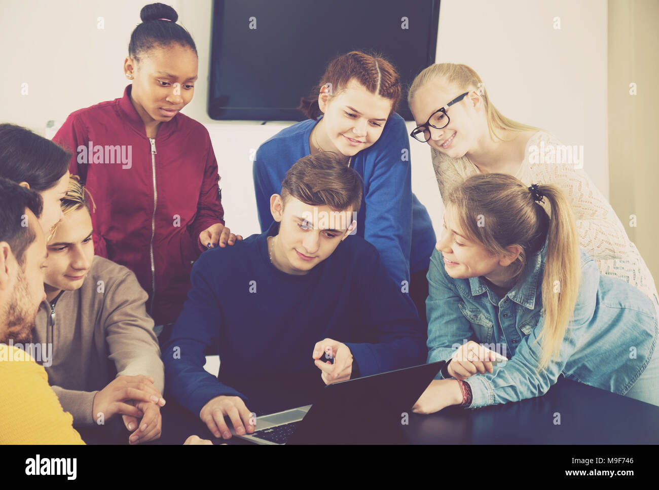 young classmates having difficult project to complete during class sits ...