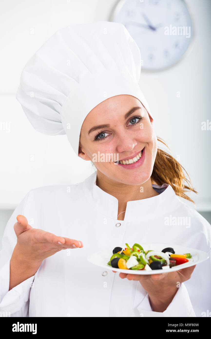 smiling girl cook with chestnut hair shows plate of salad Stock Photo ...