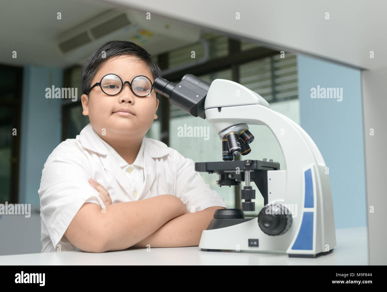 smart boy working with microscope in laboratory, science and educaton ...