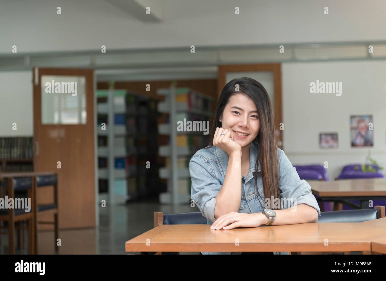 Confident smiling student asian girl in the library, sitting and ...