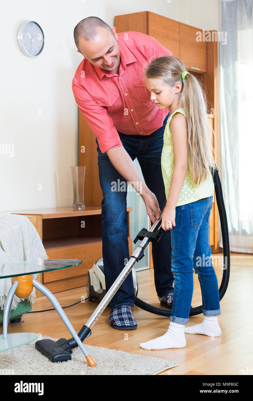 Little girl helping father to do clean-up indoors Stock Photo - Alamy