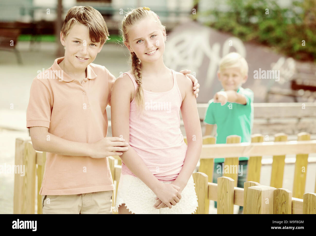 Smiling girl and boy are walking while their friend feeling aggrieved ...