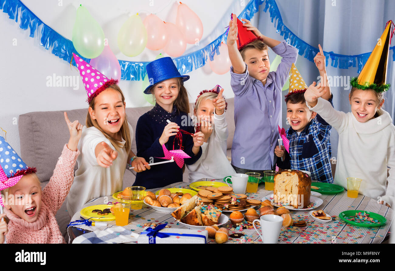 Glad positive smiling boys and girls behaving jokingly during friend’s ...