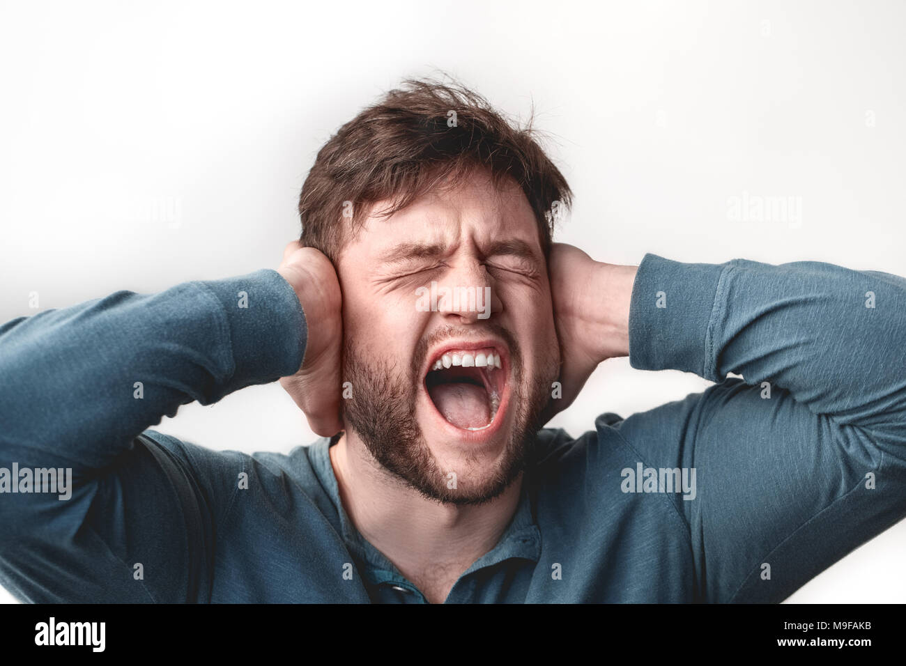Man isolated on white wall facial expressions close-up screaming loud ...