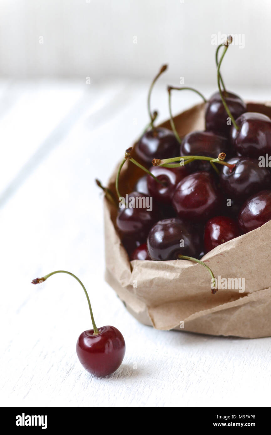 Fresh cherry berries in a paper bag, isolated on a white background ...