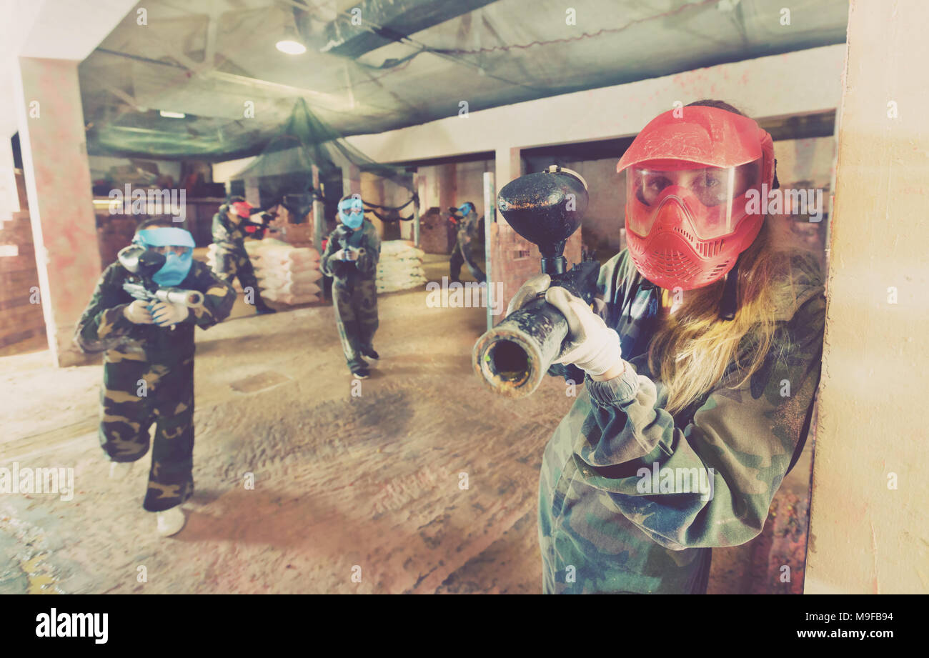 Player in red mask is targeting in enemy in a battlefield in paintball ...