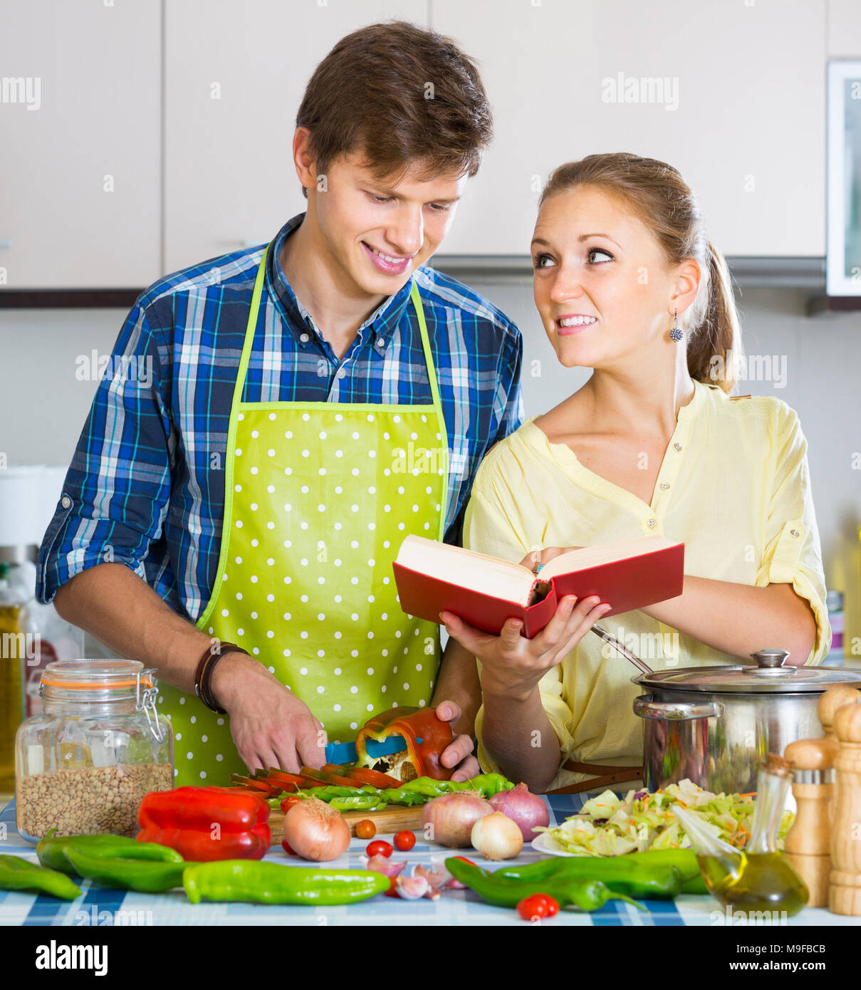Happy russian man and woman standing near table in domestic kitchen ...