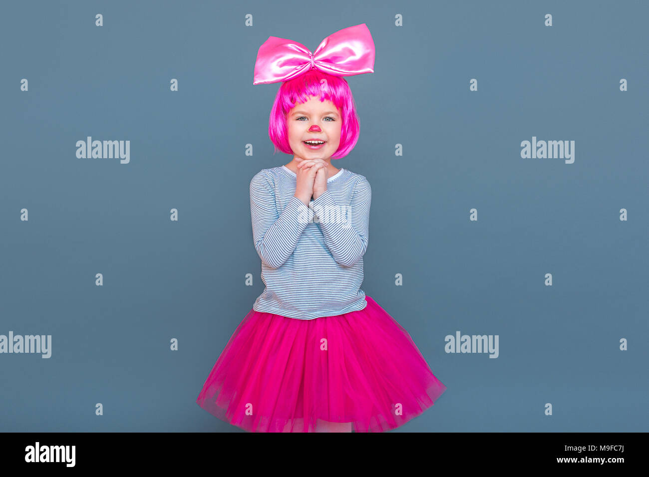 Closeup portrait of toothy smiling happiness little pink clown. Studio ...