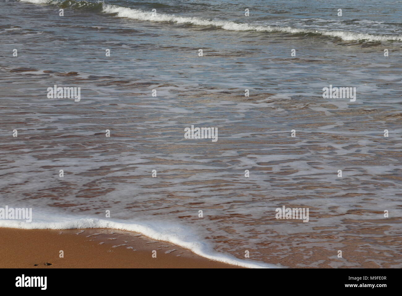 Waves arriving on beach Stock Photo - Alamy