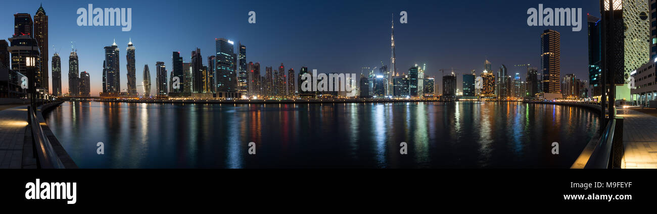 Panoramic view of Business bay skyline with reflection in the water at ...