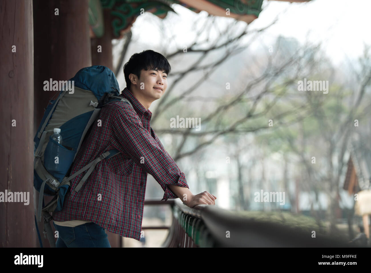 A young man doing a backpacking trip in a Korean traditional house ...