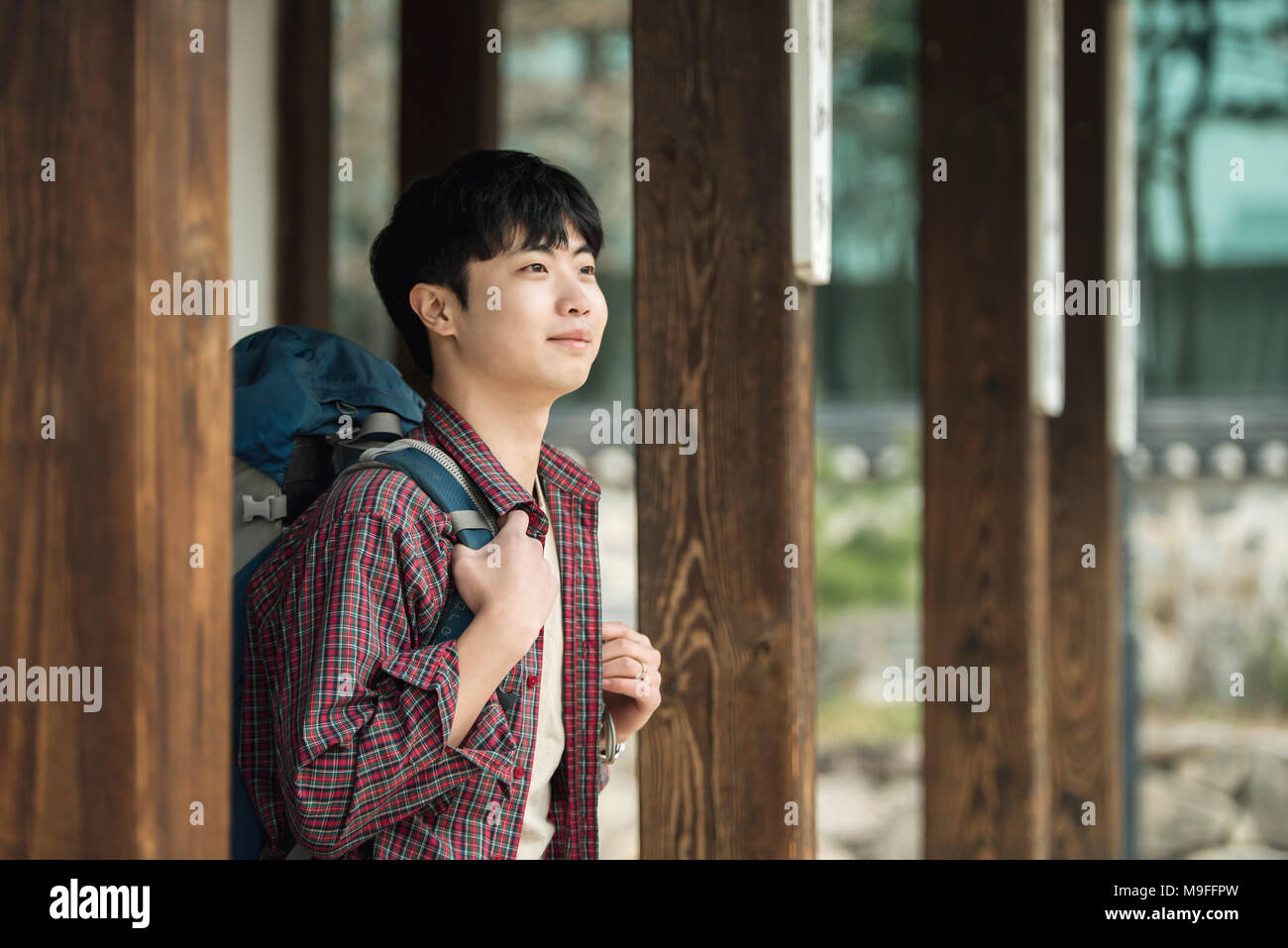 A young man doing a backpacking trip in a Korean traditional house ...