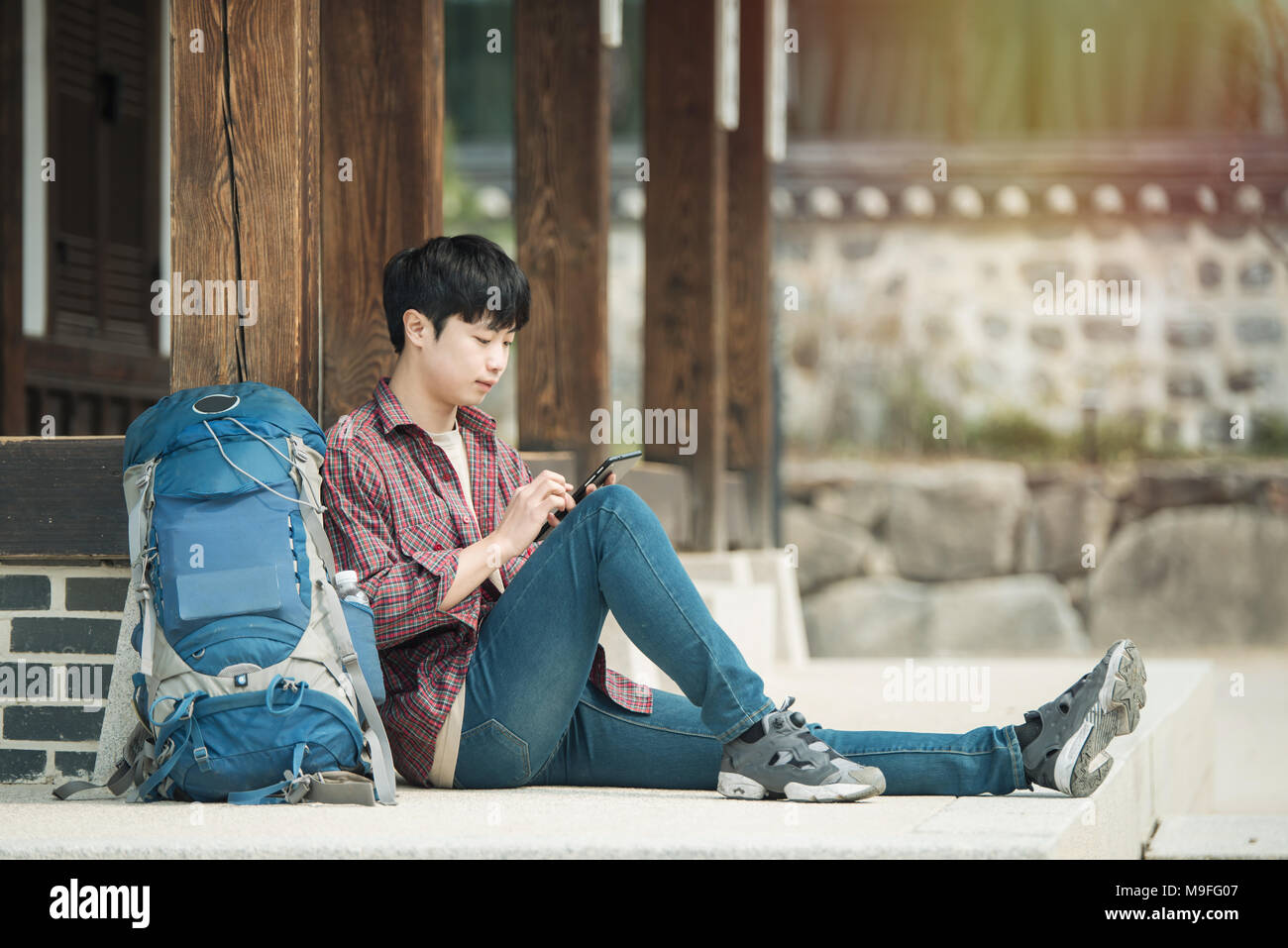 A young man backpacking in Korea. sitting in a Korean traditional house ...