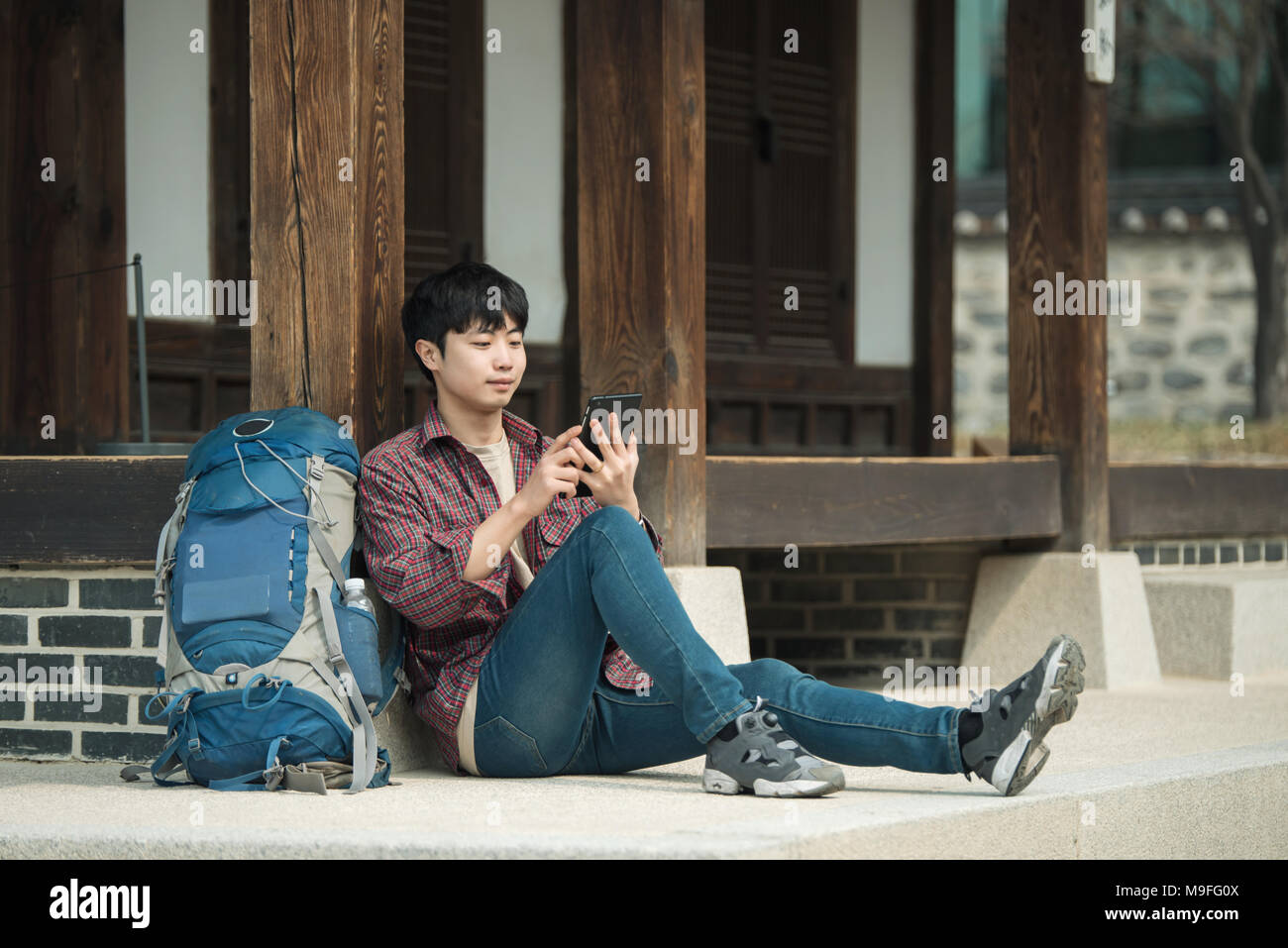 A young man backpacking in Korea. sitting in a Korean traditional house ...