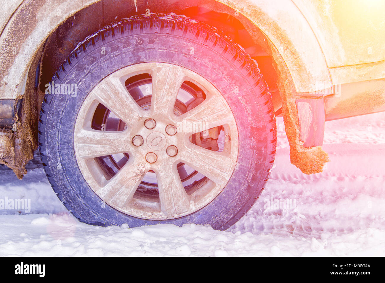 the wheel of the truck on the winter road, stalled in the melted snow ...
