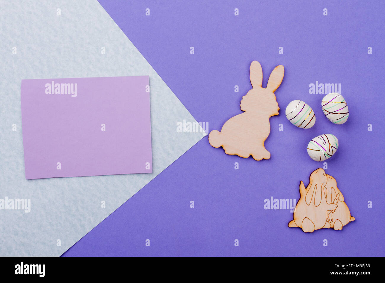 Easter decorations on purple background. Plywood rabbits and styrofoam ...