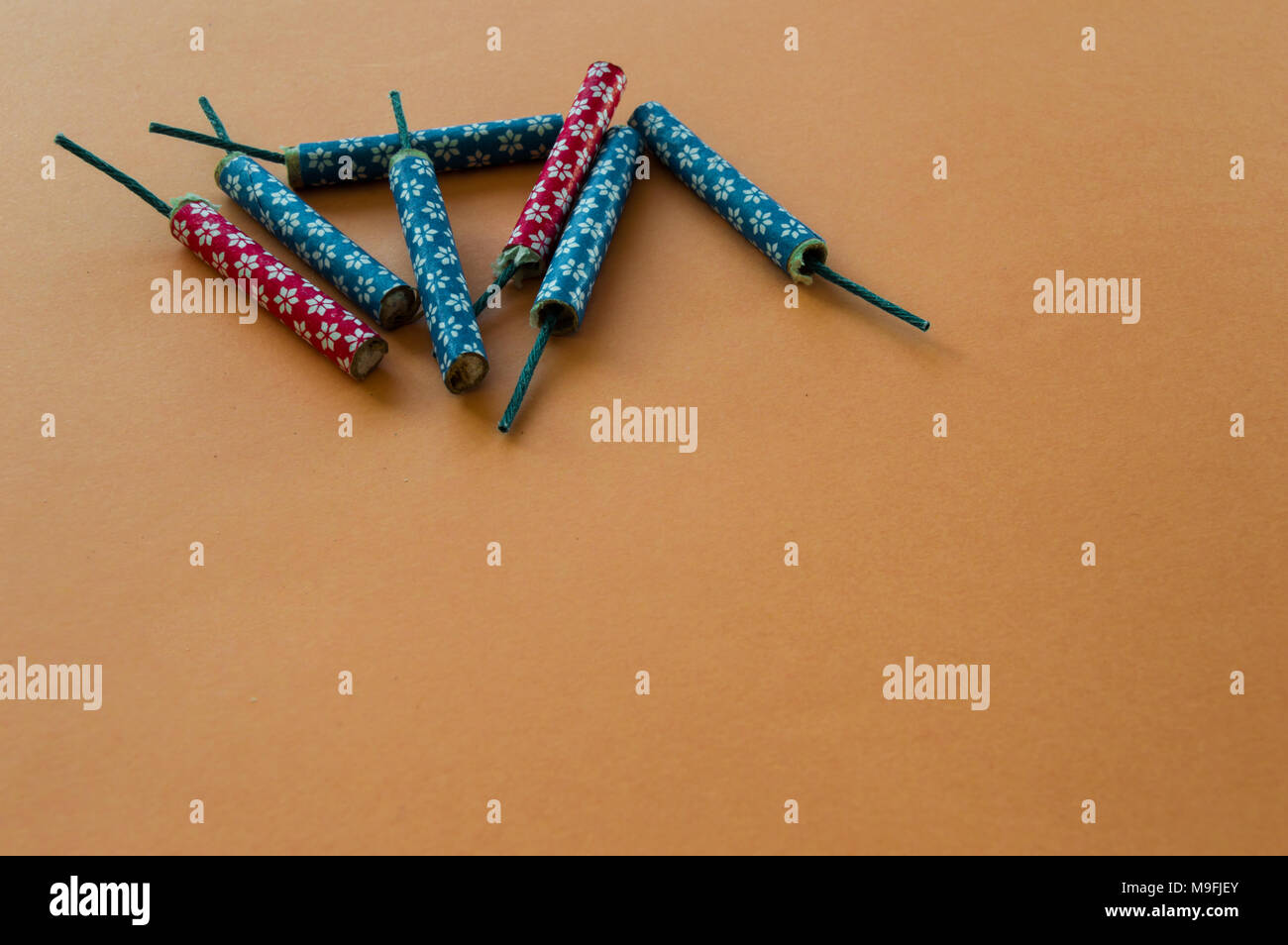 Pretty red and blue firecrackers isolated on orange background Stock ...