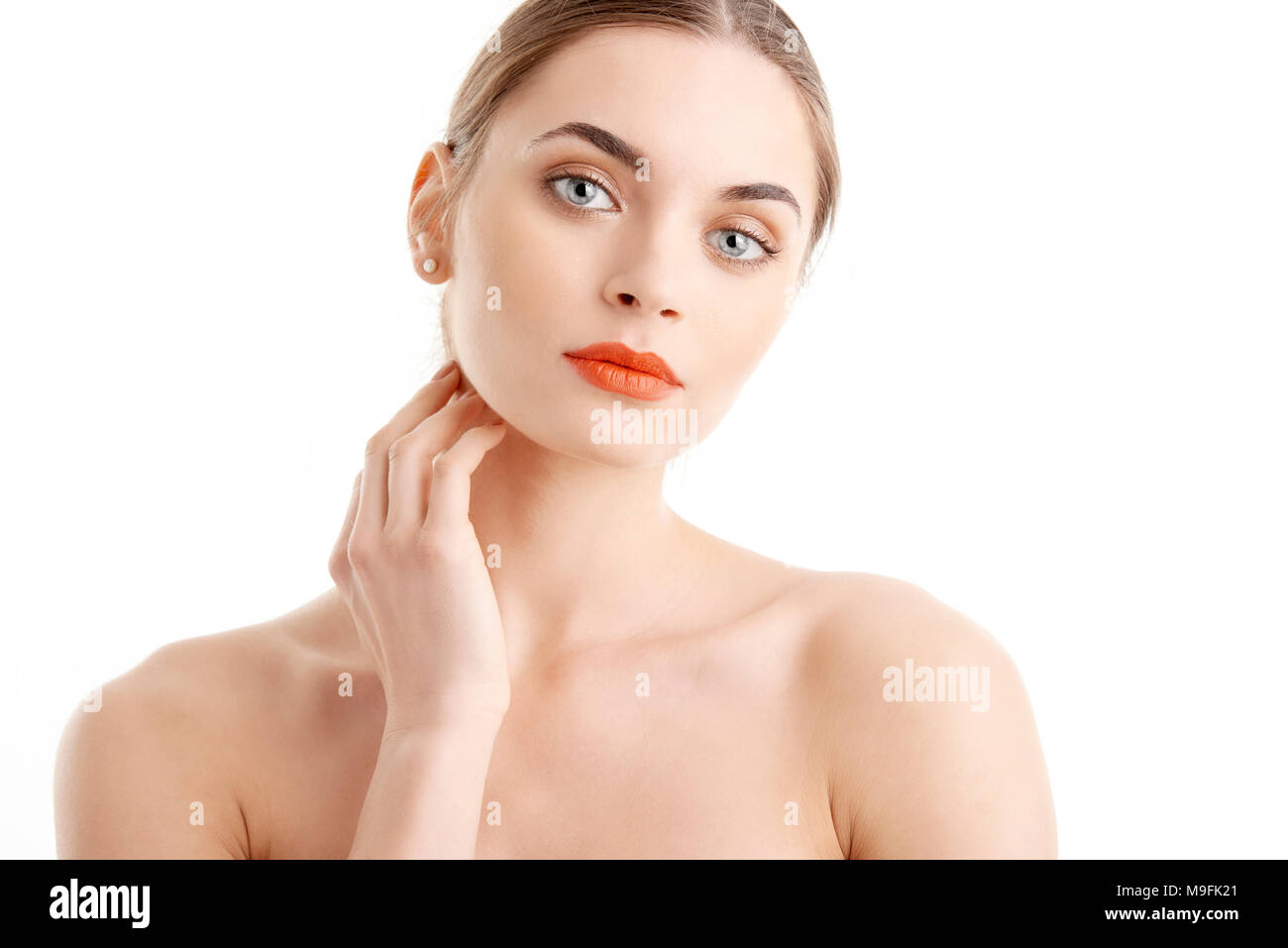 Close-up of beautiful young woman with hand on her face looking at ...